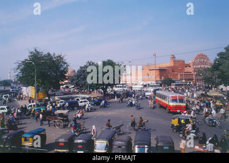 Street scene with cars, bicycles, pedestrians, a man walking with two ...