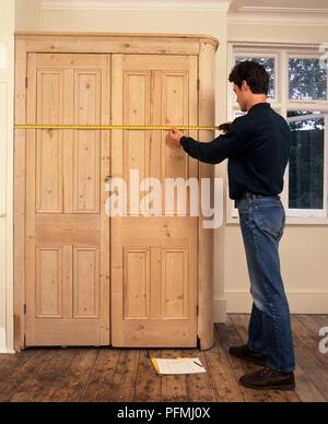 Measuring length with a tape measure on a table Stock Photo - Alamy