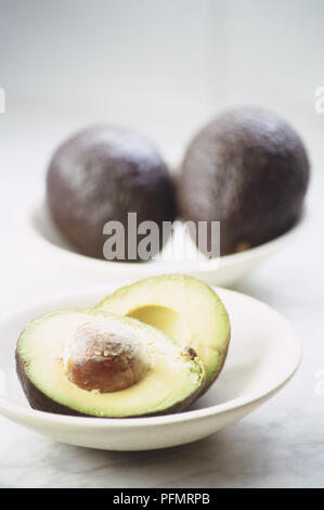 Side view of avocado fruit a whole and a half isolated on white ...