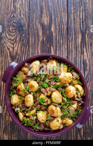 Dish of potatoes with mushrooms on a wooden background Stock Photo - Alamy