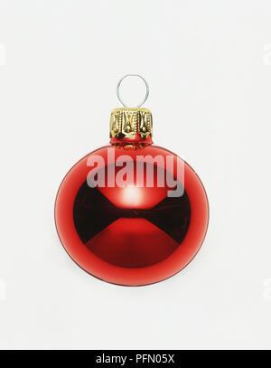Single red Christmas bauble in front of a gold glitter background for ...