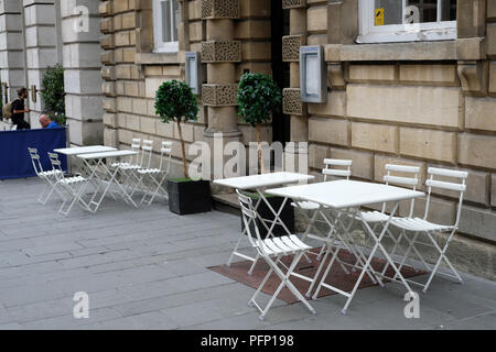 August 2018 - White tables and chairs outside a cafe in an old building ...