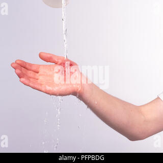 Caucasian man rinsing hand under water Stock Photo - Alamy