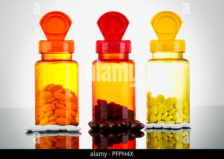 row of bottles with pills in the front container on white background ...