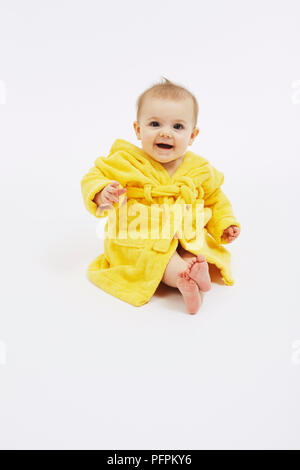 Crossed legs of the baby on a white background. A little girl lies on a ...