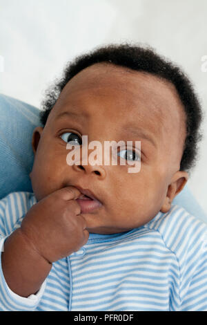 Close-up portrait of cute boy biting lip at home Stock Photo - Alamy