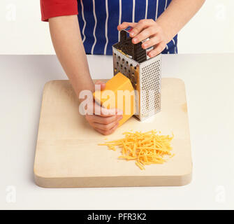 Hand grating cheese with a cheese grater onto a plate Stock Photo - Alamy