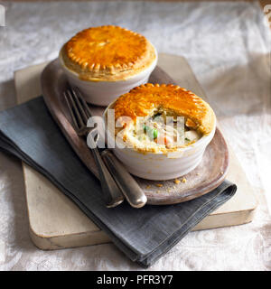 Two chicken pot pies on serving tray, with cutlery Stock Photo - Alamy