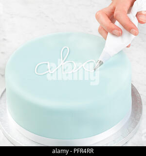 Piping letters on top a smooth iced cake Stock Photo - Alamy