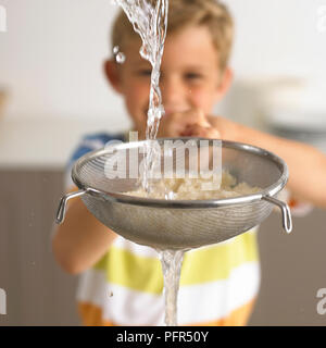Washing rice in a sieve with water, 6 years Stock Photo - Alamy