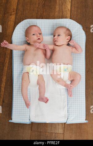 Twin baby girls both lying on back, 13 weeks Stock Photo - Alamy