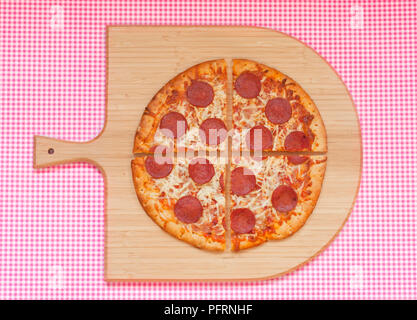 Pepperoni pizza cut into four quarters, one slice slightly removed from ...