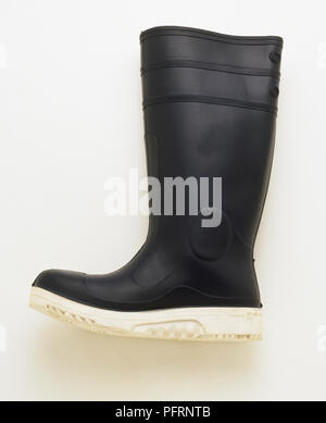 A vertical shot of a black rubber boot isolated on the coast Stock ...