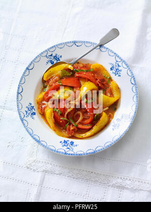 Overhead view of a bowl of tomato and basil salad with a slice of bread ...