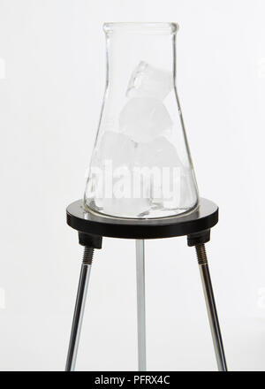 Glass conical flask on a tripod containing water being heated Stock ...