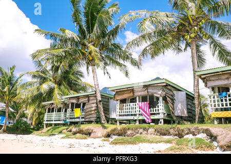 Traditional Tongan fale on a beach with palm trees on Uoleva, Tonga ...