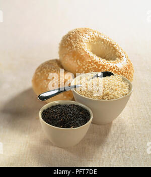 Black sesame seeds in white ceramic bowl with wooden spoon and brown ...