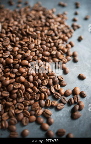 Coffee bean in focus close up against blurred beans on green background ...