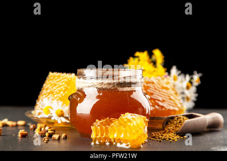 Honey jar and dipper with leaking honey Stock Photo - Alamy