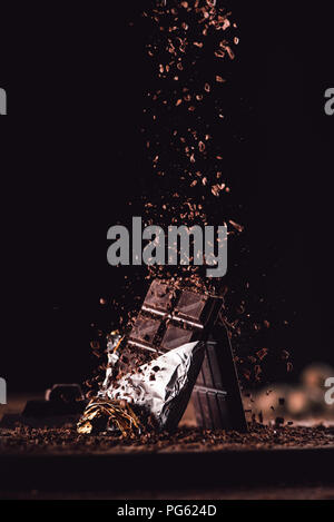 Chocolate Bars falling on Black Chocolate Powder Stock Photo - Alamy
