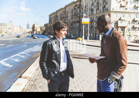 Russia, Moscow, two businessmen in front of modern office buildings ...