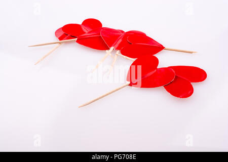 Red hearted sticks scattered on a white background Stock Photo - Alamy