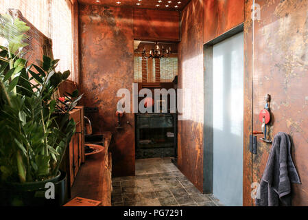Modern bathroom with corten steel wall cladding and ceiling light ...