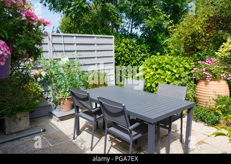 Flowered terrace with gray garden furniture in wrought iron during ...