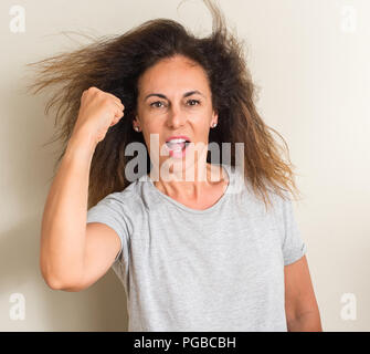 Curled hair brazilian woman annoyed and frustrated shouting with anger ...