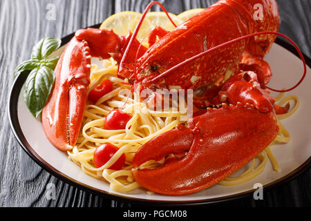 Italian recipe of spaghetti with boiled lobster, tomatoes, lemon and ...