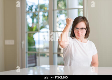 Down syndrome woman at home annoyed and frustrated shouting with anger ...