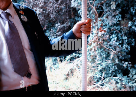 Old Fashioned type of Bus Conductor holding on to the rail of the rear ...