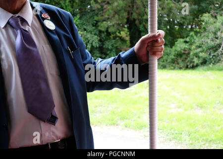 Old Fashioned type of Bus Conductor holding on to the rail of the rear ...