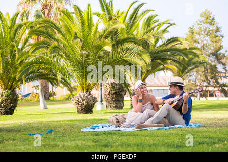People sitting on the grass and eating lunch in a small city park, St ...