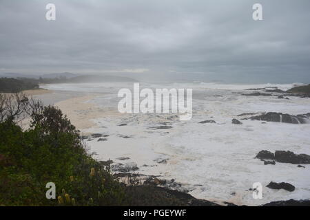 Foamy Sawtell beach in Winter, choppy seas, waves crashing over rocks ...