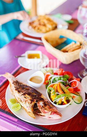 Fresh grilled fish served with salad and lemon in Mediterranean style ...