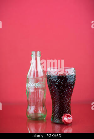 Coca-Cola Classic opened bottle with filled glass standing on white ...
