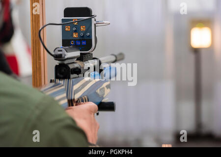 A blind man is aiming a specially equipped rifle at the target on a ...