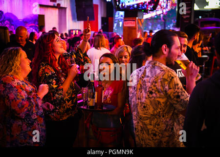 Inside a Coyote Ugly bar, where women dance on the bar as people order ...