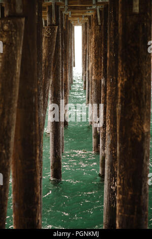 wooden pier and boardwalk with dock pylons on the edge of an idyllic ...