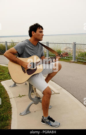 Portrait of stylish man playing guitar, performing isolated over white ...