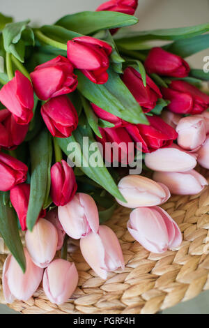 Bouquet of red and while flowers laying on a neutral colored table ...
