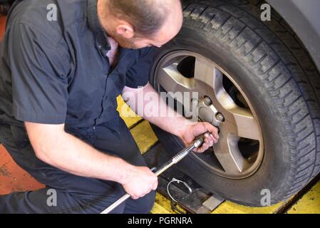 Hands of mechanic removing car tire from disc on machine. Man working ...
