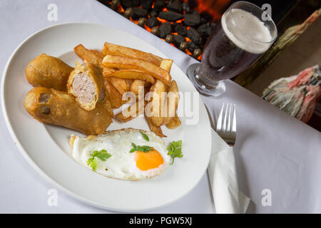 Traditional English supper of deep fried battered sausage with chips ...