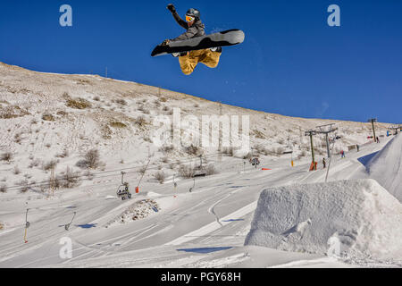 A freestyle snowboarder makes a backside air grab Stock Photo - Alamy