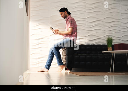 Young man with tablet computer video chatting on online date at home ...