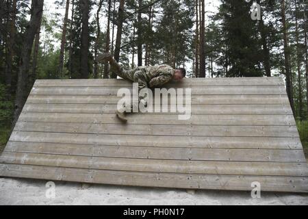 An armed soldier jumps over a wall Stock Photo - Alamy