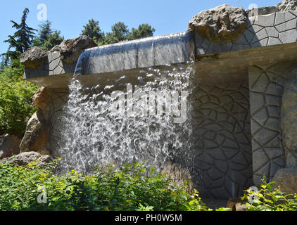 Artificial waterfall with water jets, modern stone structure, beautiful ...