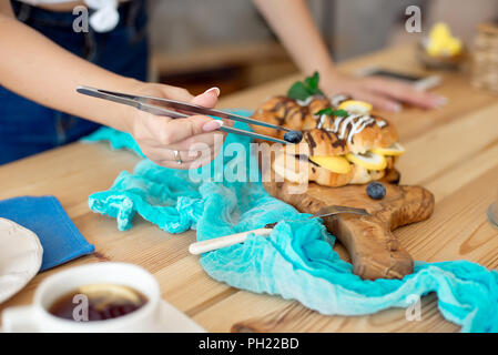 Unrecognizable woman decorating chocolate cupcake with sprinkles ...
