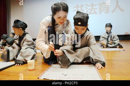 Students write the Chinese character "Ren," meaning "Human" in English ...